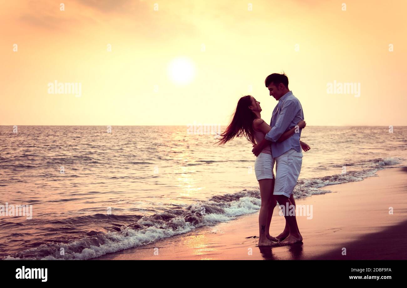 Romantic young Couple hug on the beach at sunset Stock Photo - Alamy