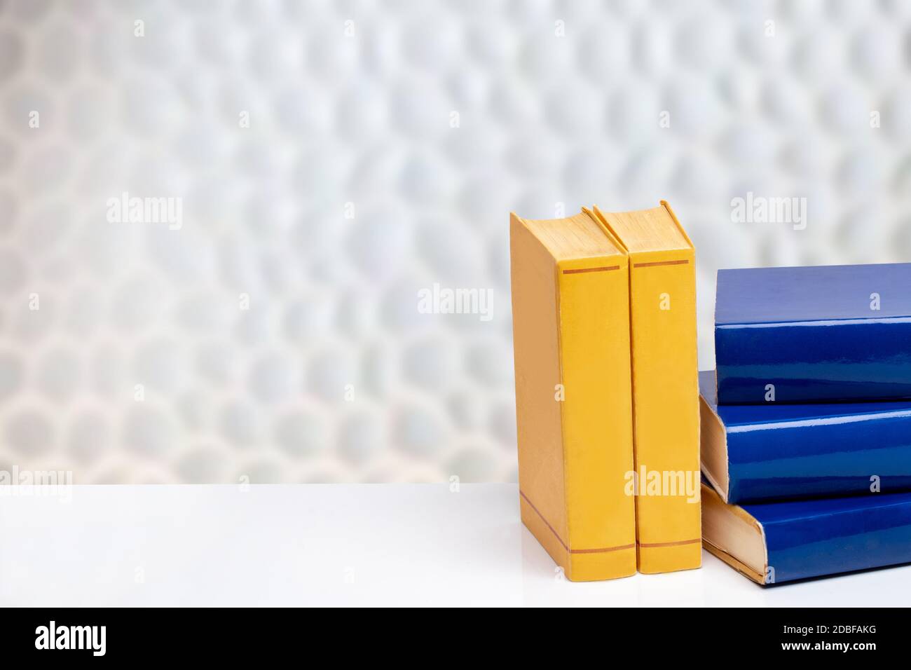 Books backgrounds. Close-up of a stack blue and yellow books on a white ...