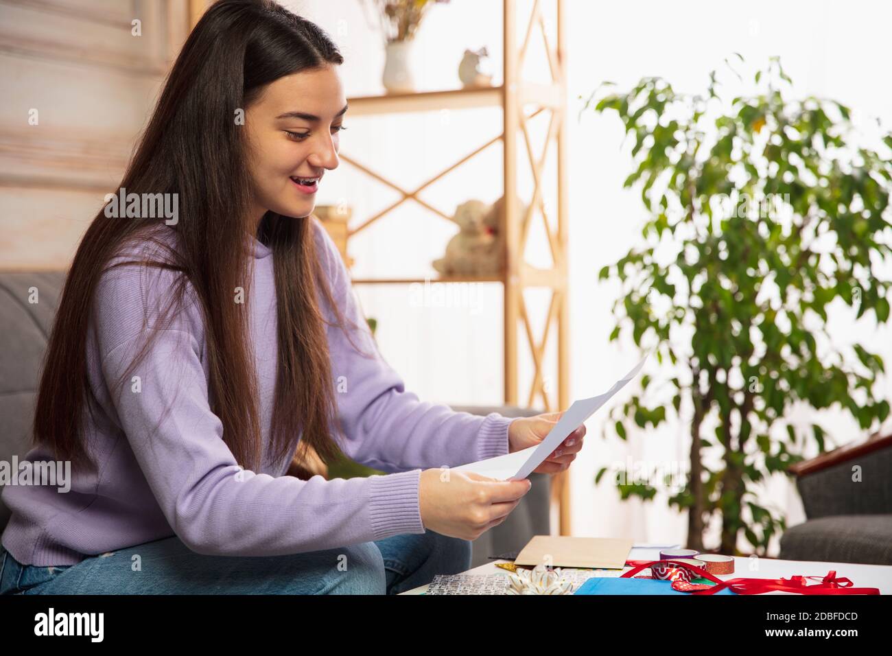 Comfortable. Woman opening, recieving greeting card for New Year and ...