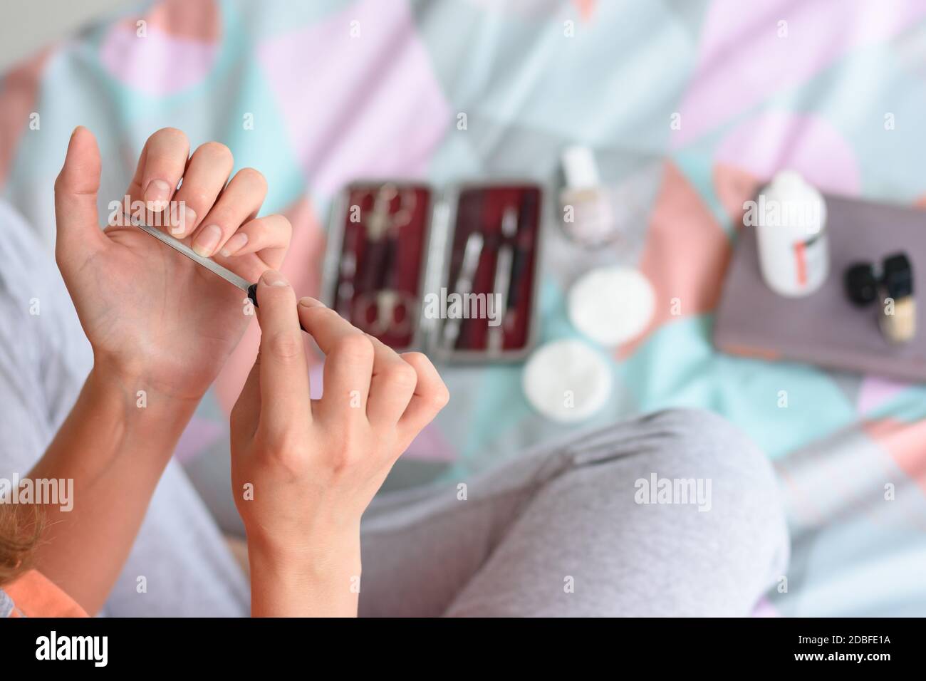 Girl files a fingernail with a nail file Stock Photo - Alamy