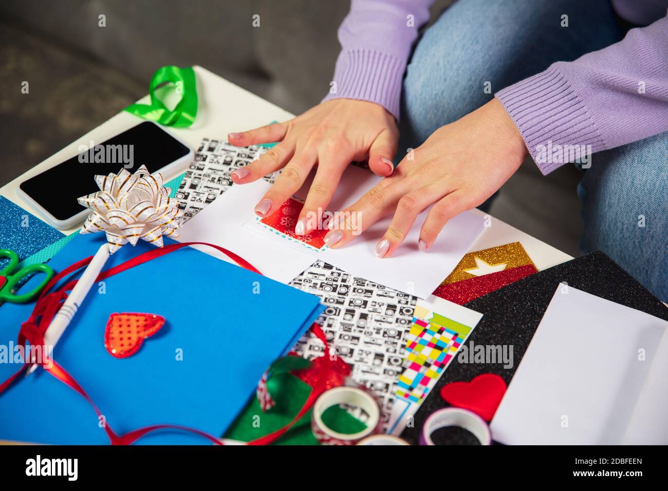 Close up female hands making greeting card for New Year and Christmas ...