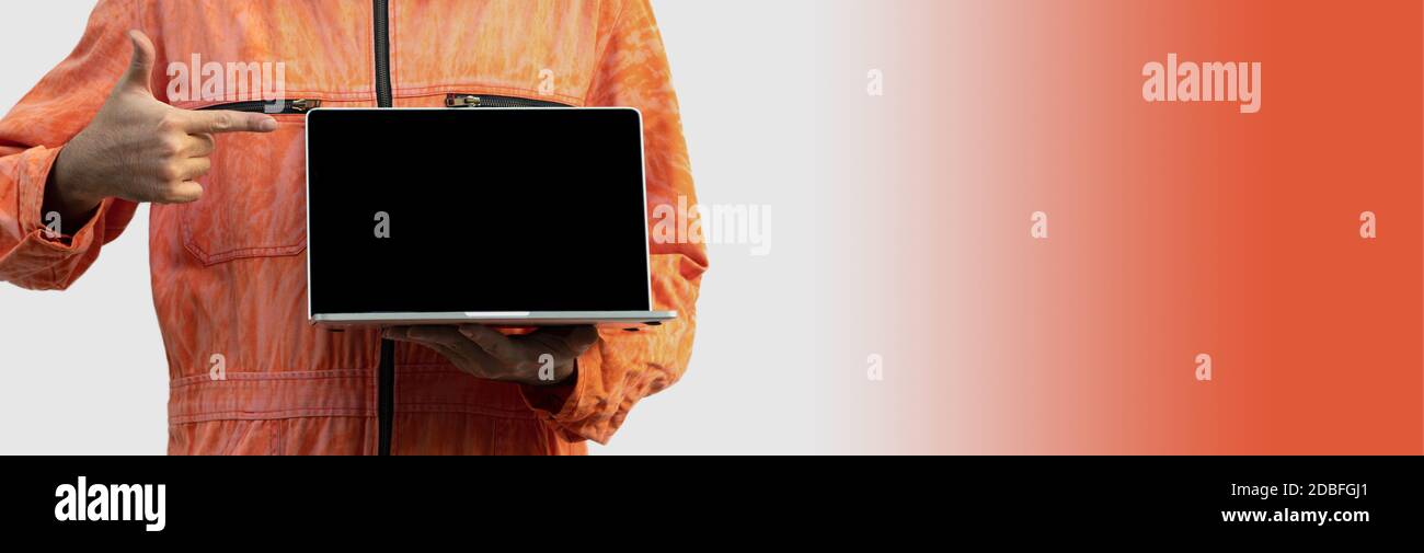 The chief mechanic in an orange uniform holding blank screen laptop ...