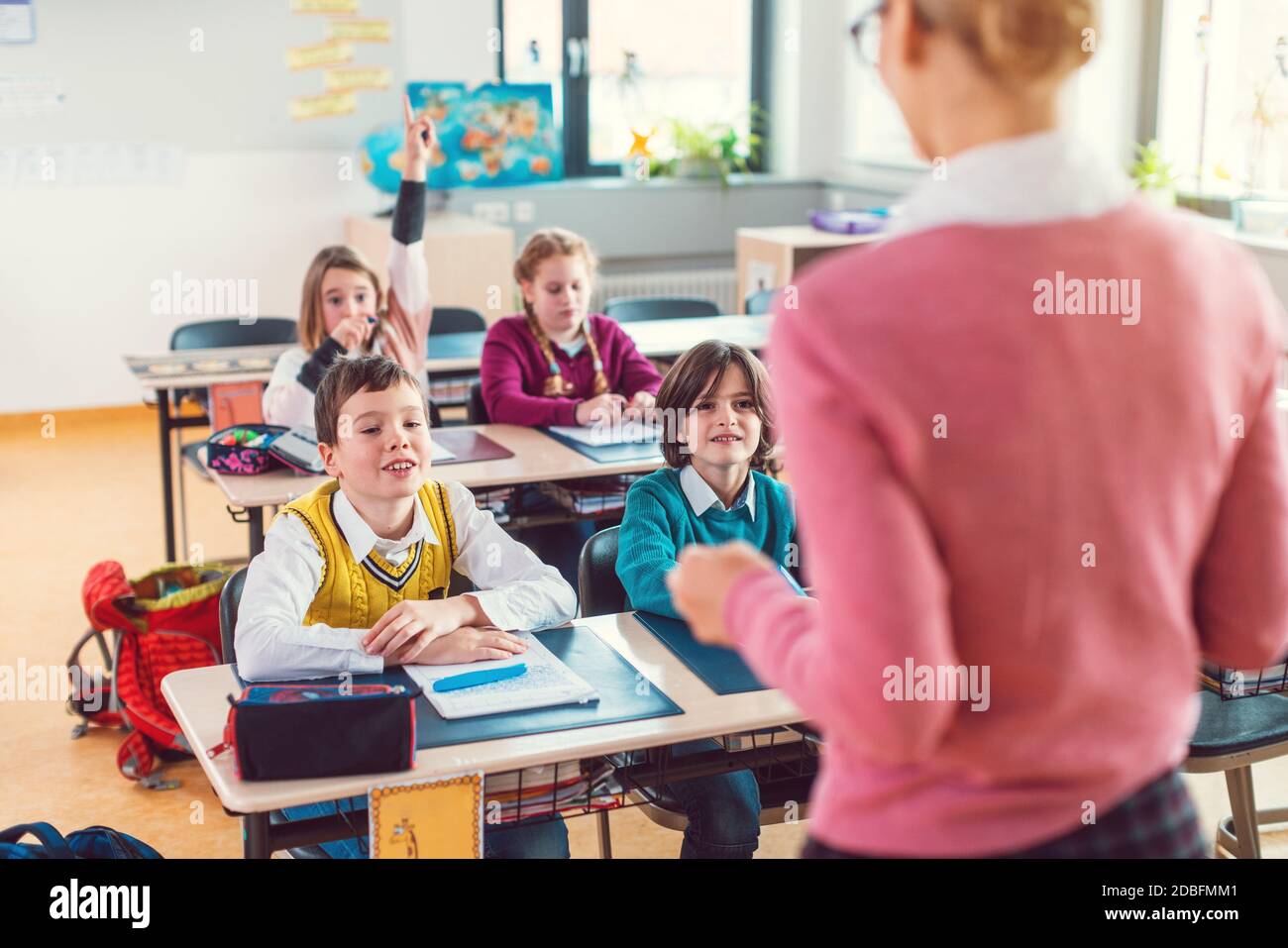 Teacher with her students in class at elementary school giving them an ...