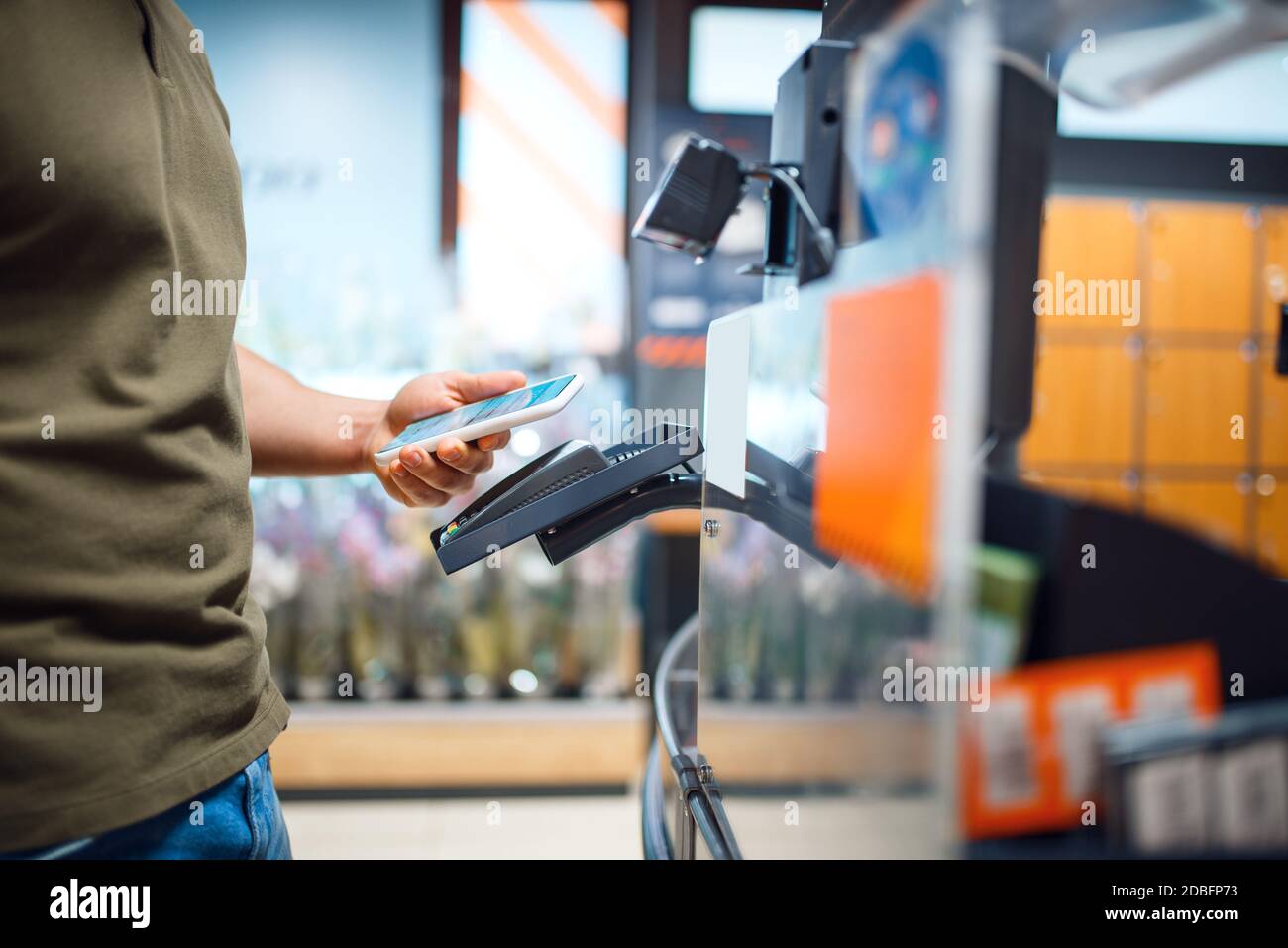 Male person pays at the checkout in grocery store. Man buying beverages ...