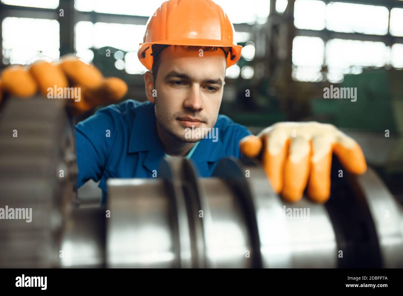 Male engineer works with turbine on factory. Industrial production ...
