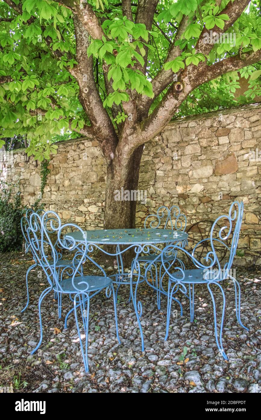 Seating group of blue chairs in the shade in the village of Villars ...