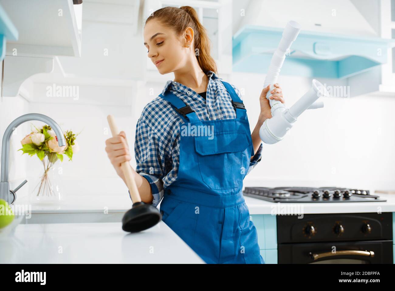 Cute female plumber in uniform holds plunger and pipe, clog in the ...