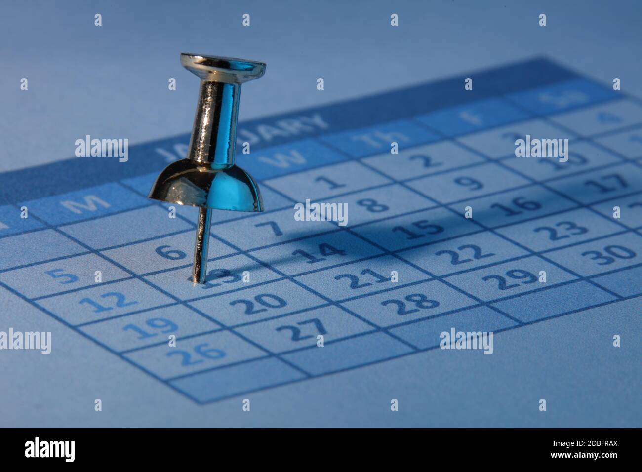 A push pin in calendar with blue light Stock Photo - Alamy