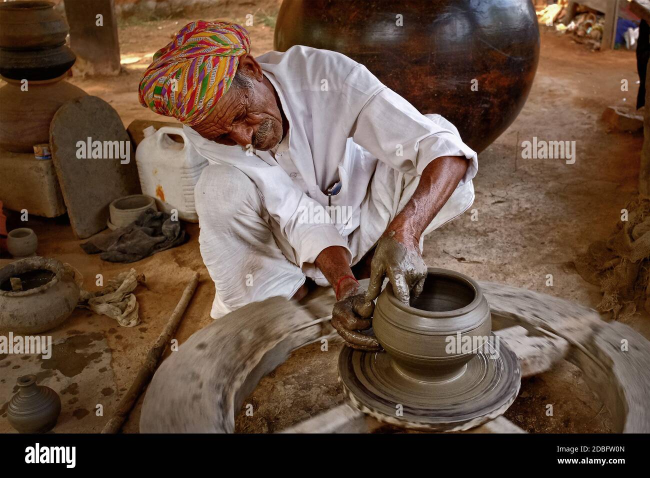 Indian potter at work: throwing the potter's wheel and shaping ceramic ...