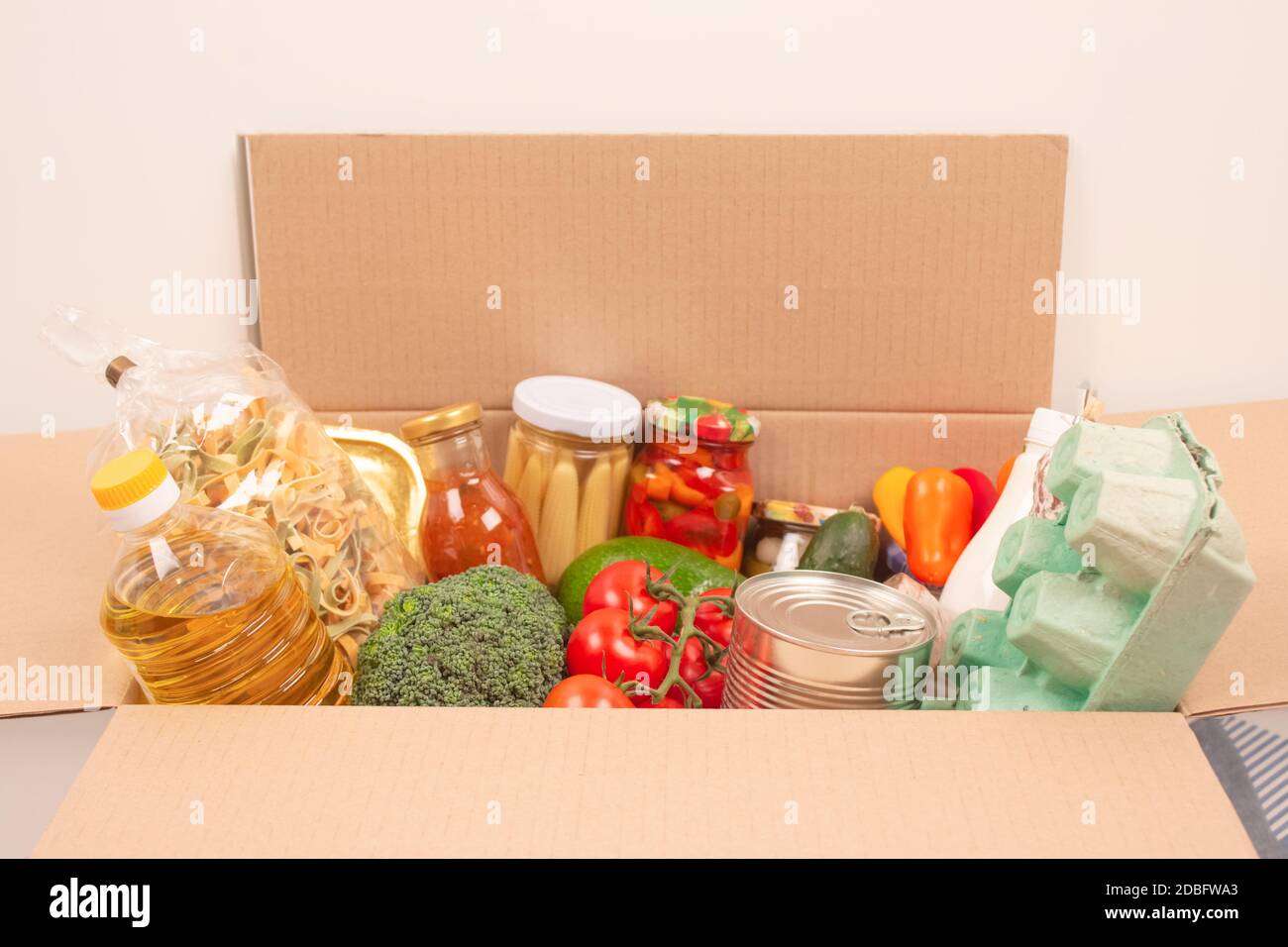 Donation box with different groceries, food donations on light ...