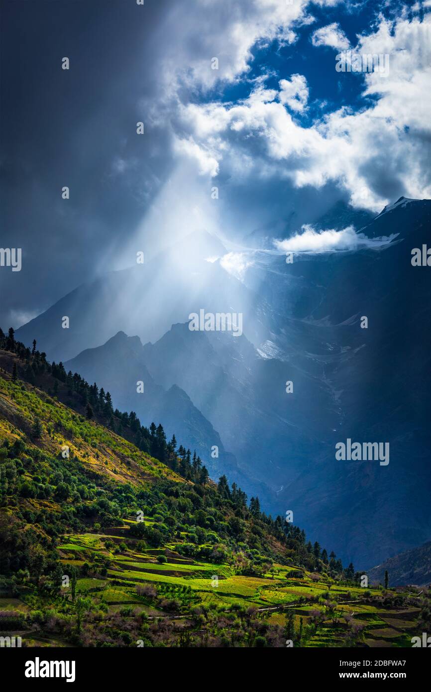 Sun rays through clouds in Himalayan valley in Himalayas. Lahaul valley ...