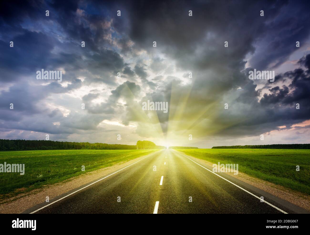 Travel concept background - road and stormy dramatic sky on sunset ...