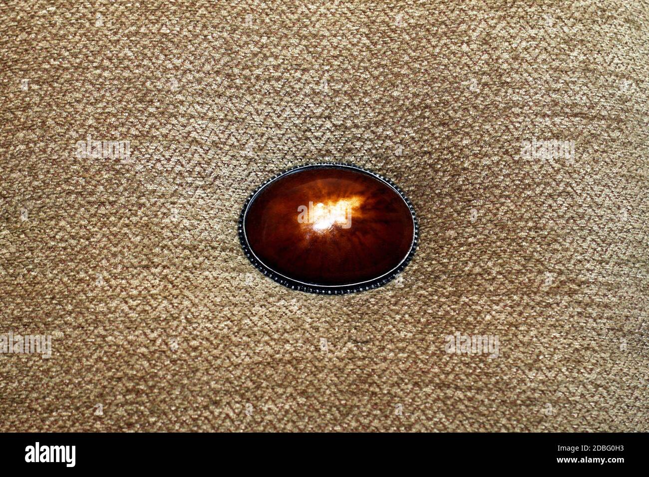 Oval amber button for decorative textile pillow Stock Photo - Alamy