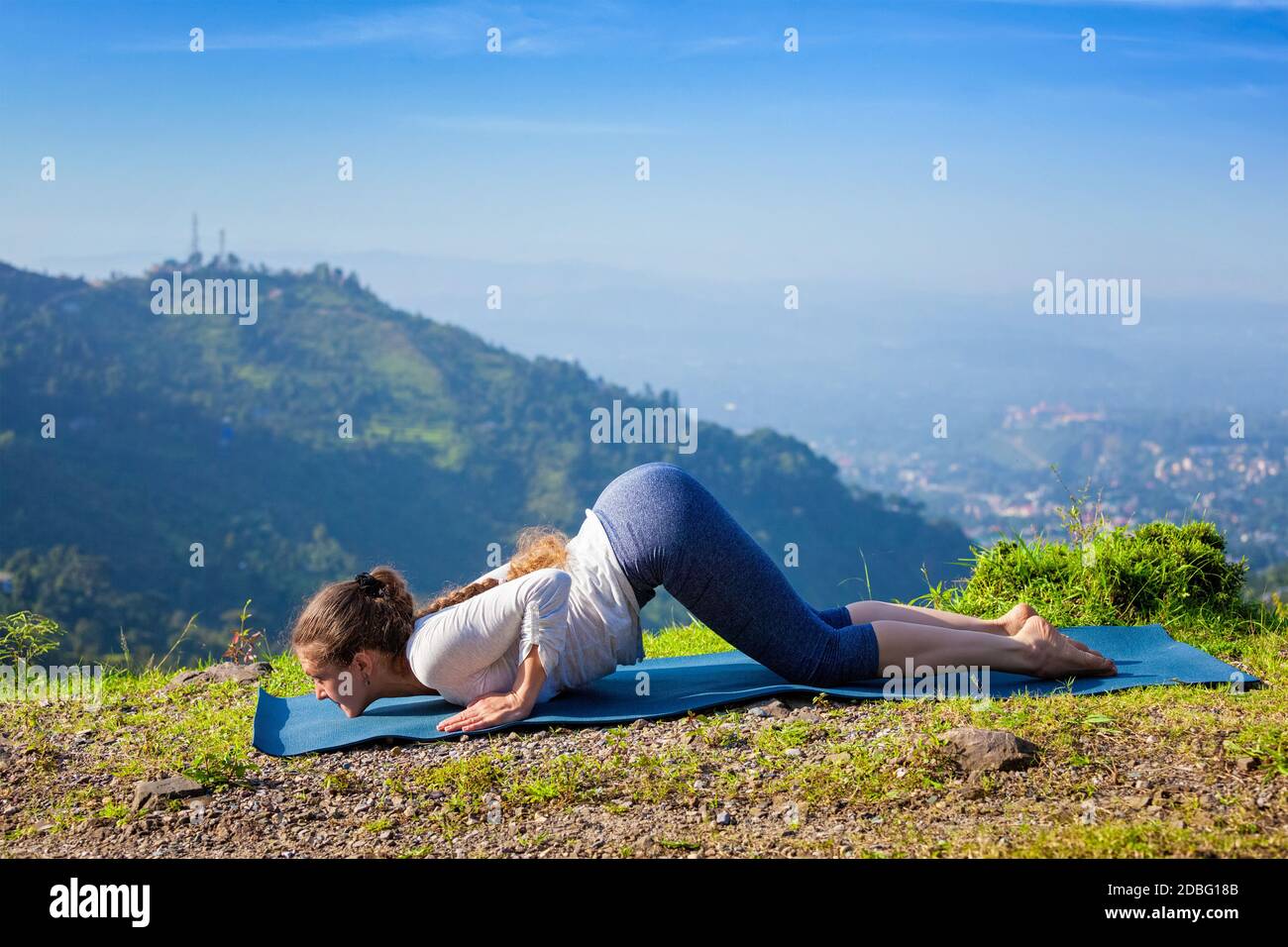 Woman doing yoga asana Ashtangasana eight-limbed pose outdoors in ...