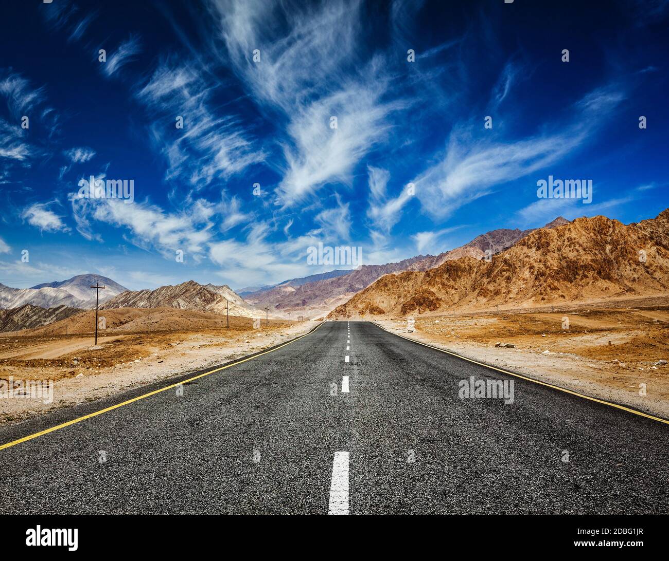 Travel forward concept background - road in mountains Himalayas with dramatic clouds on blue sky ...