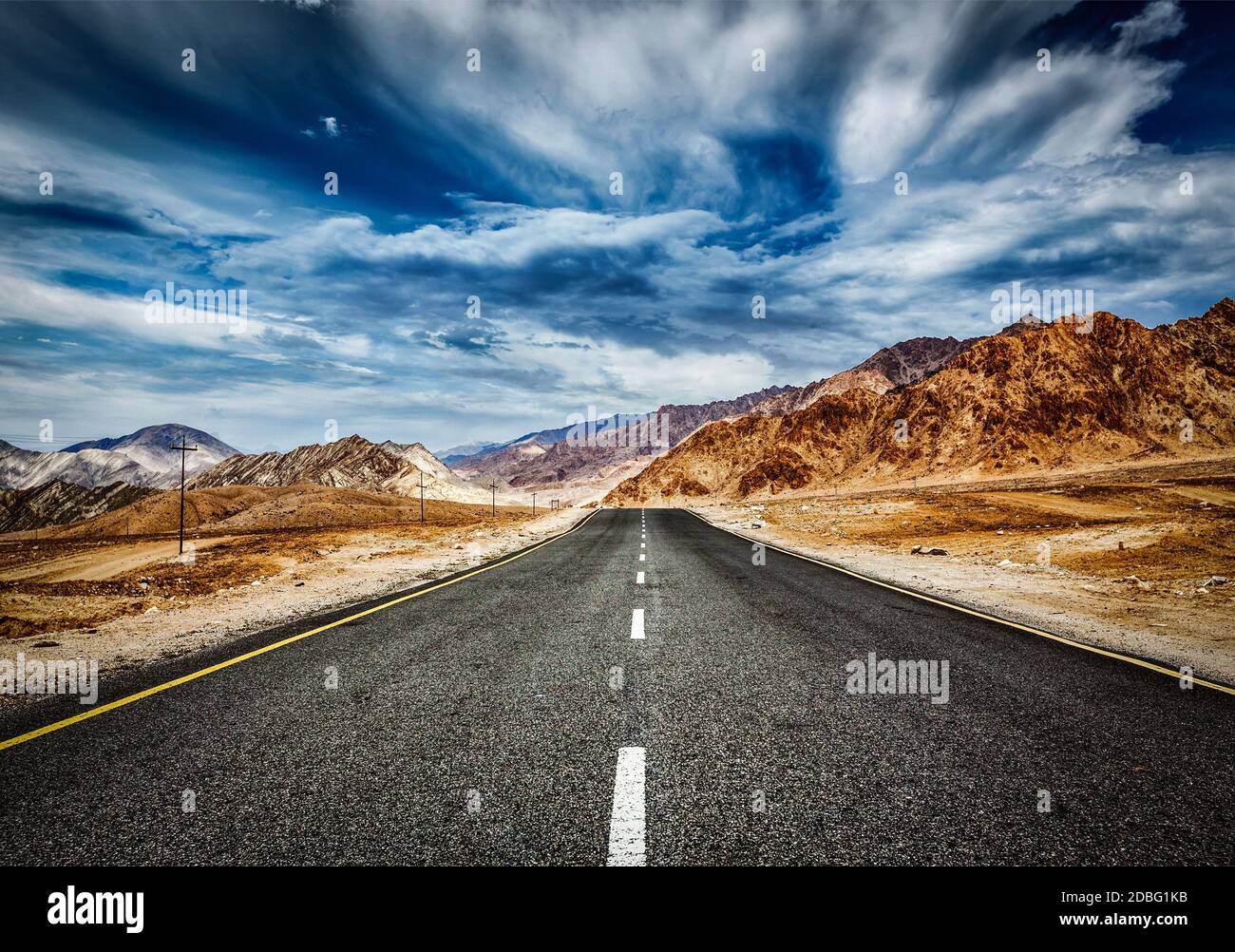 Travel forward concept background - road in Himalayas mountains and dramatic clouds. Ladakh ...