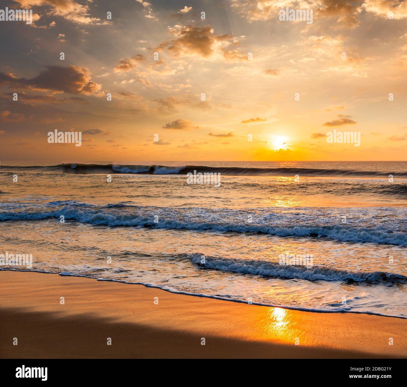 Sunrise with rising sun on morning beach Stock Photo - Alamy