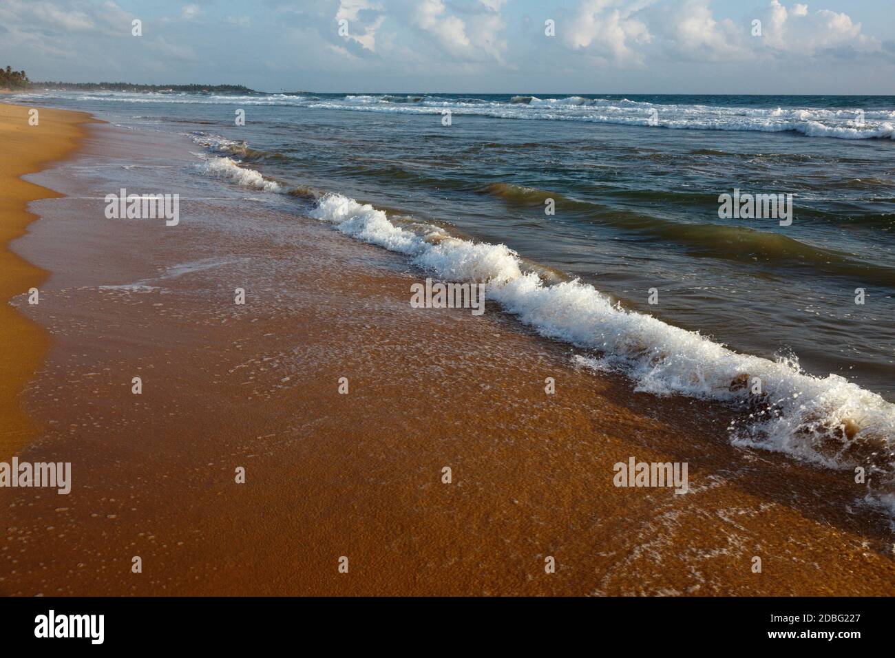 Wave surging on sand on beach Stock Photo - Alamy