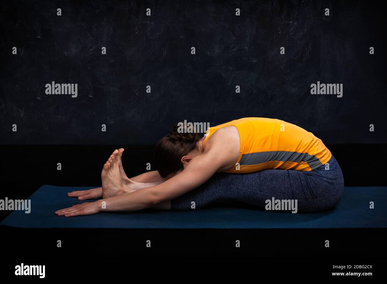 Woman doing Ashtanga Vinyasa Yoga back bending asana Paschimottanasana ...