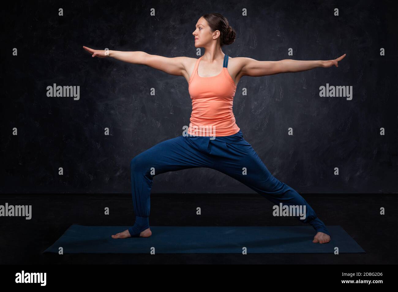 Beautiful sporty fit yogini woman practices yoga asana Virabhadrasana 2 ...