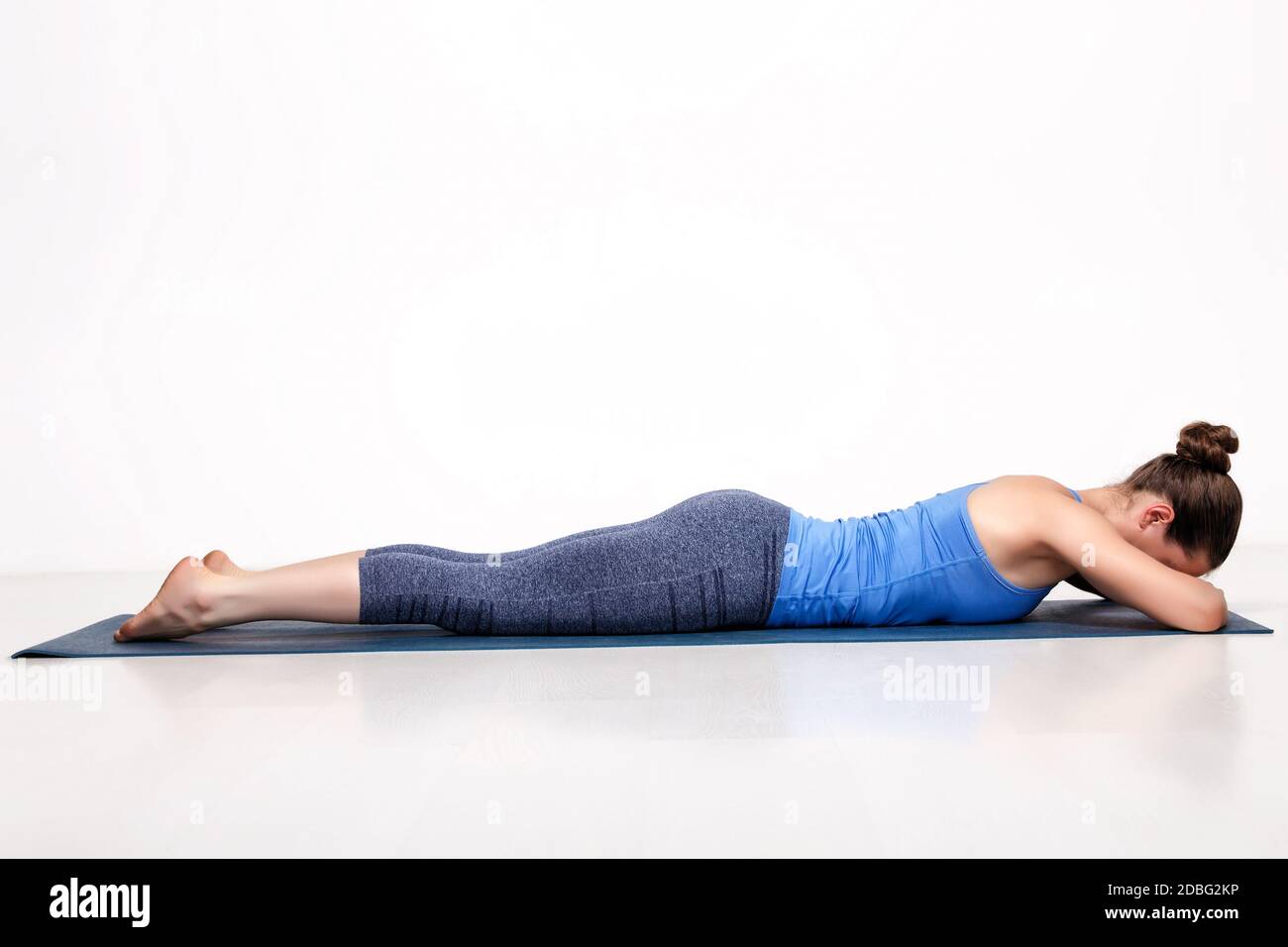Sporty woman relaxes in yoga asana Makarasana - crocodile pose Stock ...