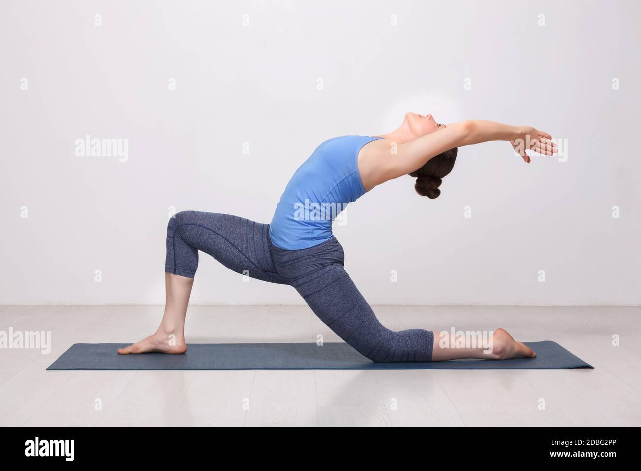 Beautiful sporty fit yogini woman practices yoga asana Anjaneyasana ...