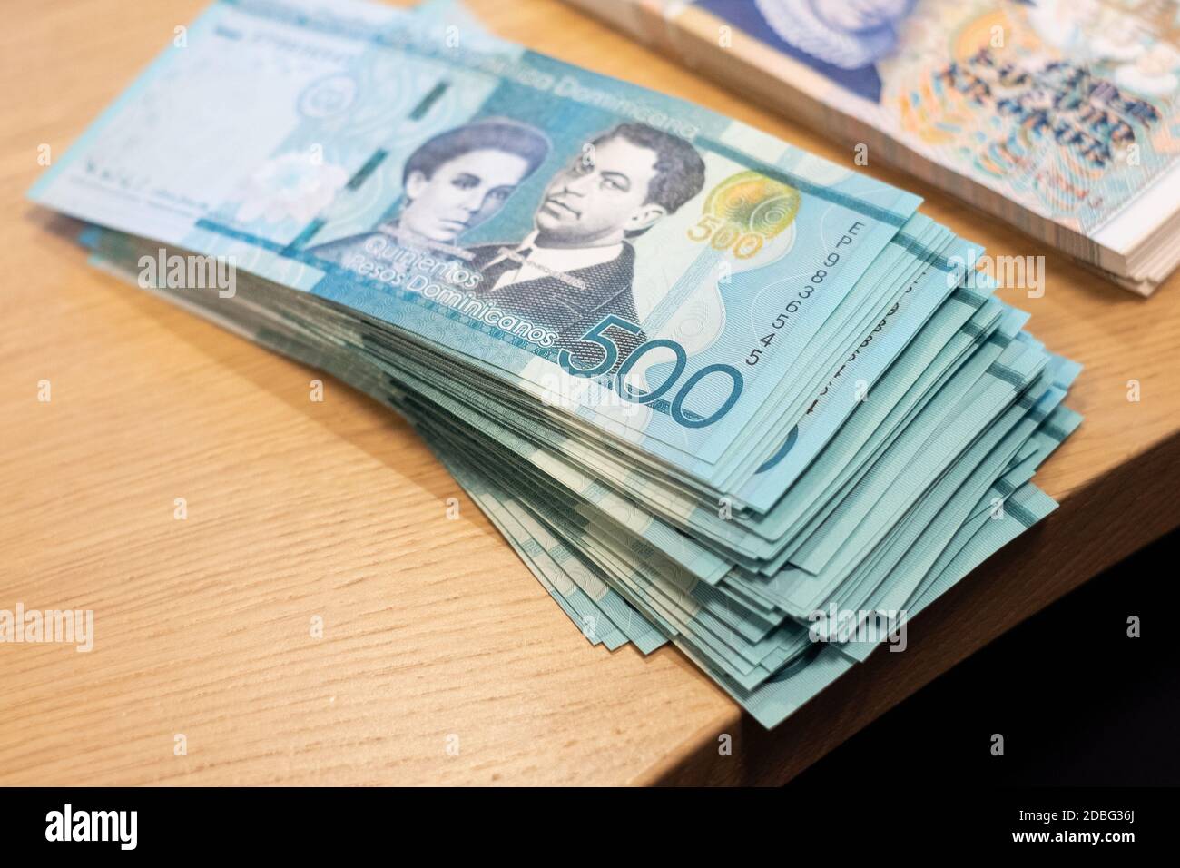 Full pack of Dominican Republic 500 peso bank notes on wooden table ...