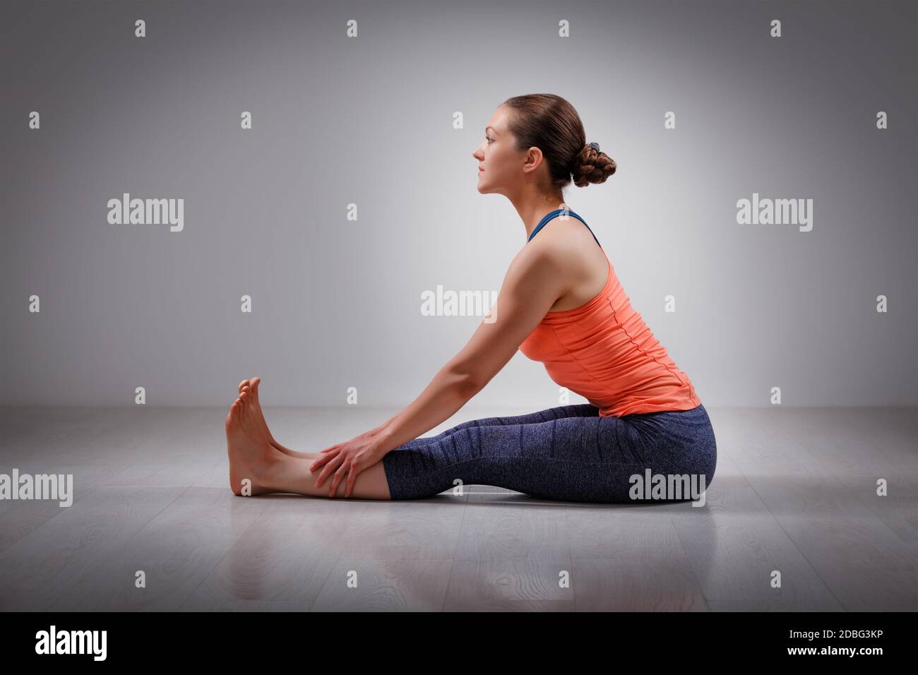 Sporty fit woman practices Ashtanga Vinyasa yoga back bending asana ...