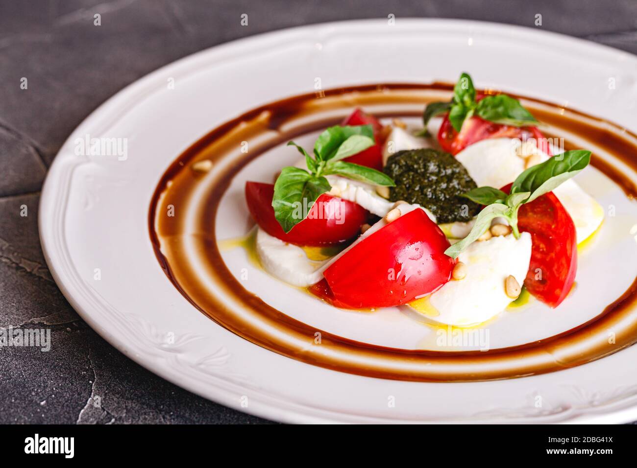 Caprese Salad With Mozzarella Tomato Basil And Pesto Arranged On