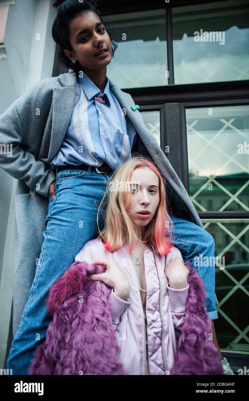 Two teenage girls infront of university building smiling, having fun ...