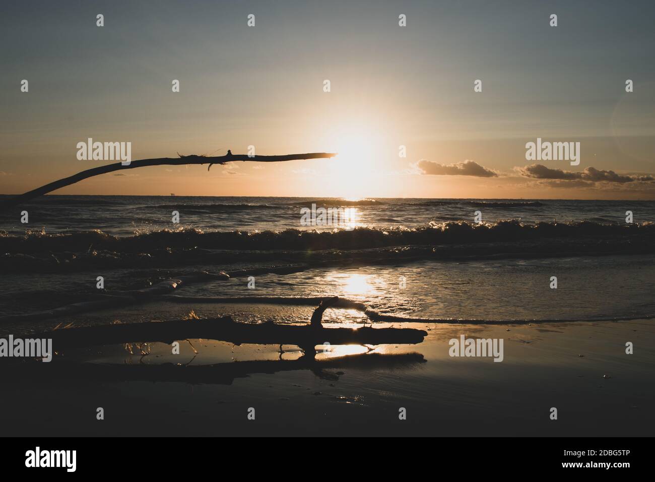 Sunset at the beach with reflection and waves Stock Photo - Alamy