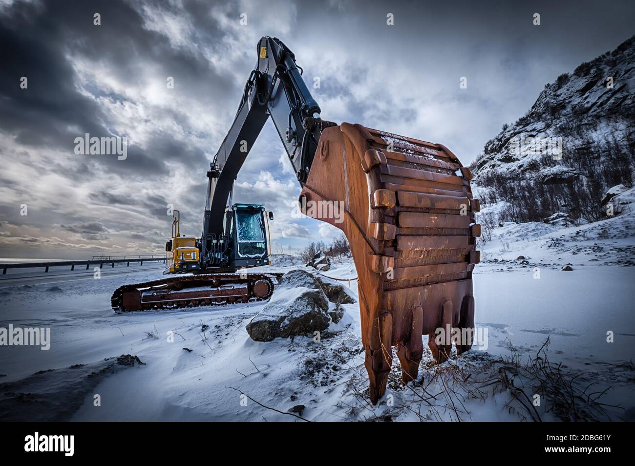 Old excavator with excavator bucket in winter. Road construction in ...