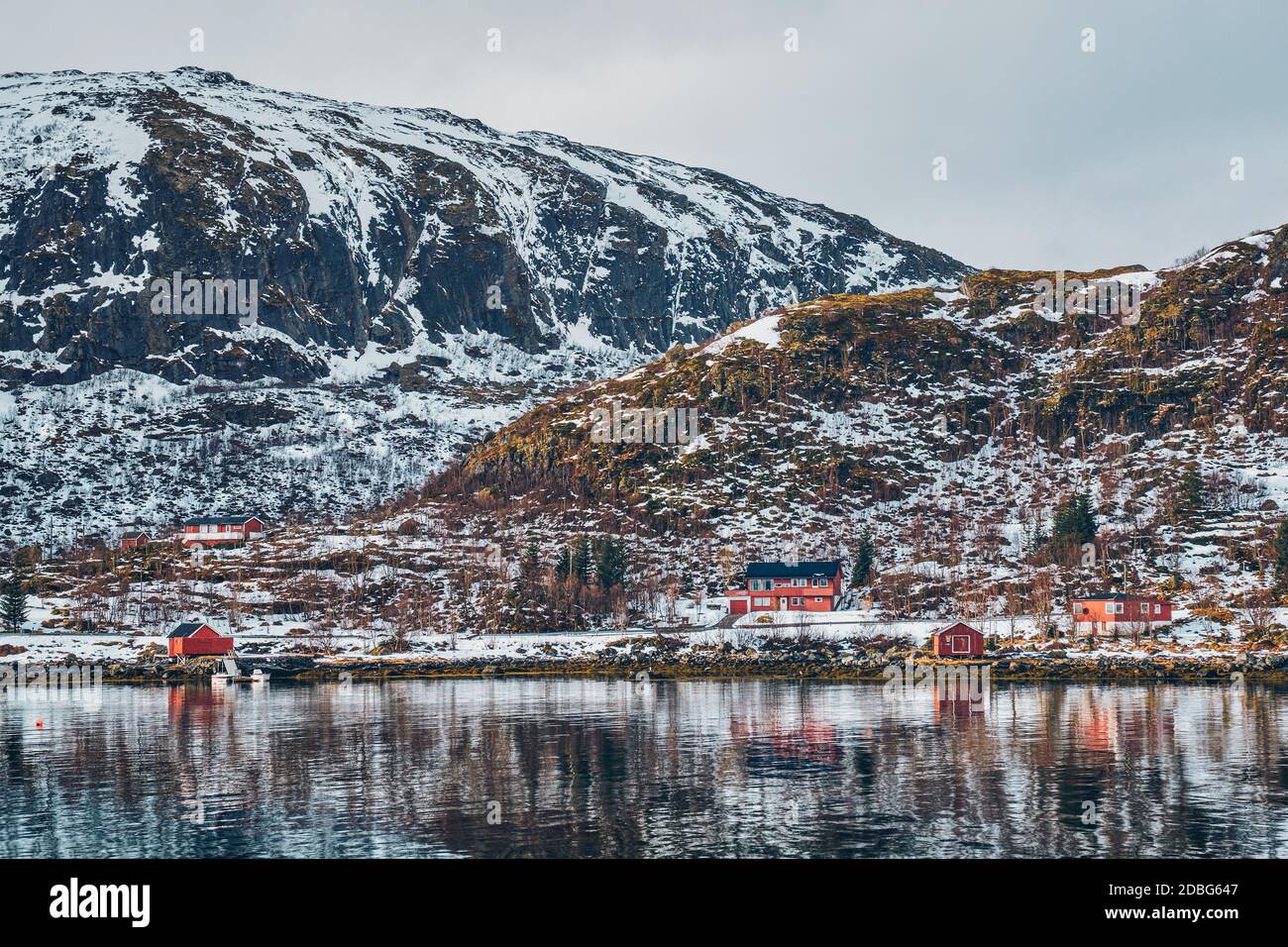 Traditional red rorbu houses on fjord shore in snow in winter. Lofoten ...