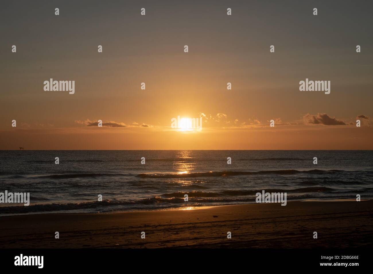 Sunset at the beach with reflection and waves Stock Photo - Alamy