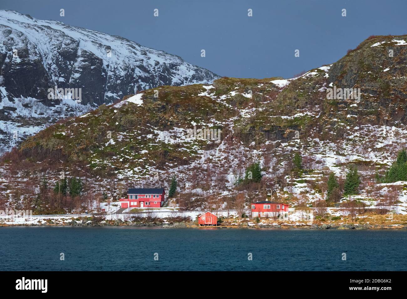 Traditional red rorbu houses on fjord shore in snow in winter. Lofoten ...