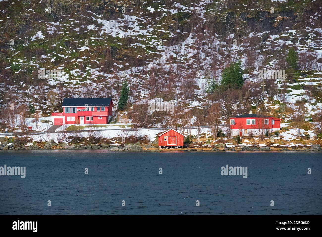 Traditional red rorbu houses on fjord shore in snow in winter. Lofoten ...