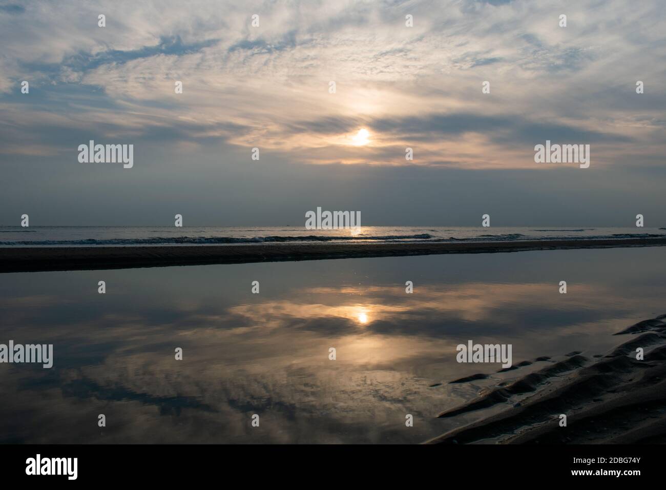 Sunset at the beach with reflection and waves Stock Photo - Alamy