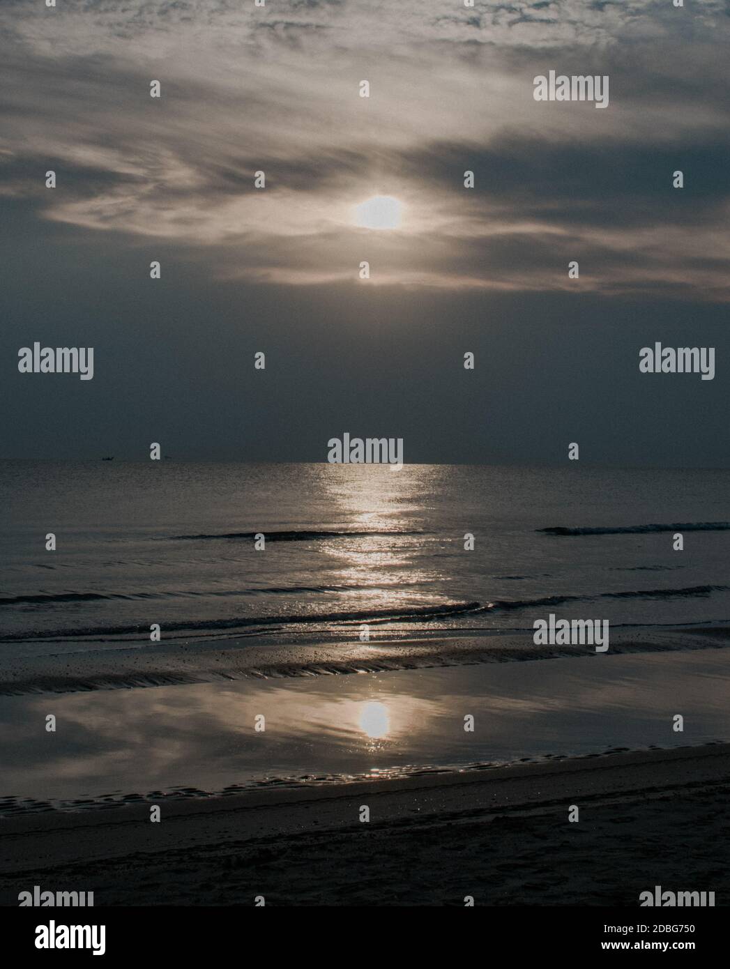Sunset at the beach with reflection and waves Stock Photo - Alamy