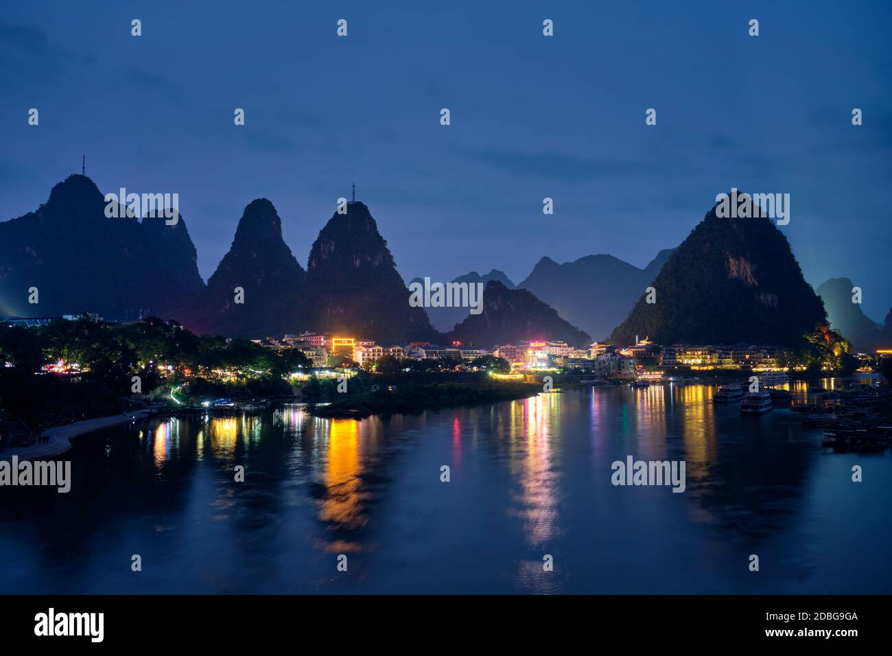 View of Yangshuo town illuminated in the evening with dramatic karst ...