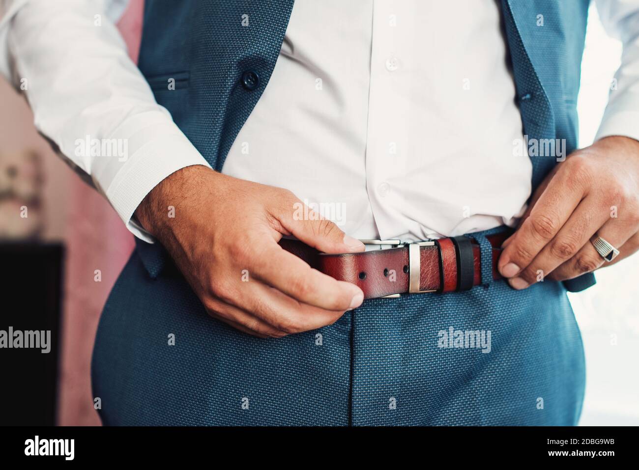 Businessman putting on a belt, fashion and clothing concept,groom ...