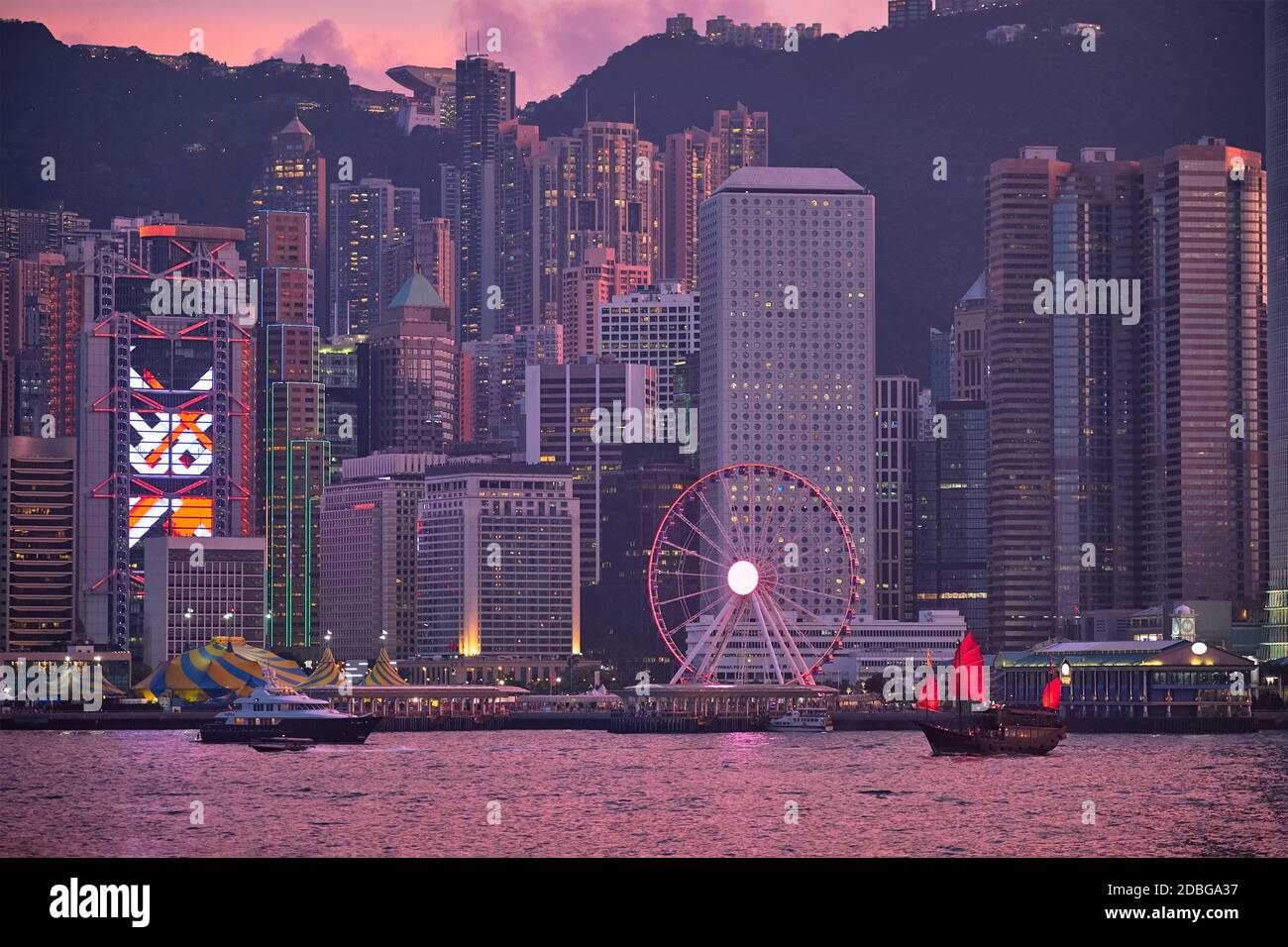 Tourist junk boat ferry with red sails and Hong Kong skyline cityscape ...
