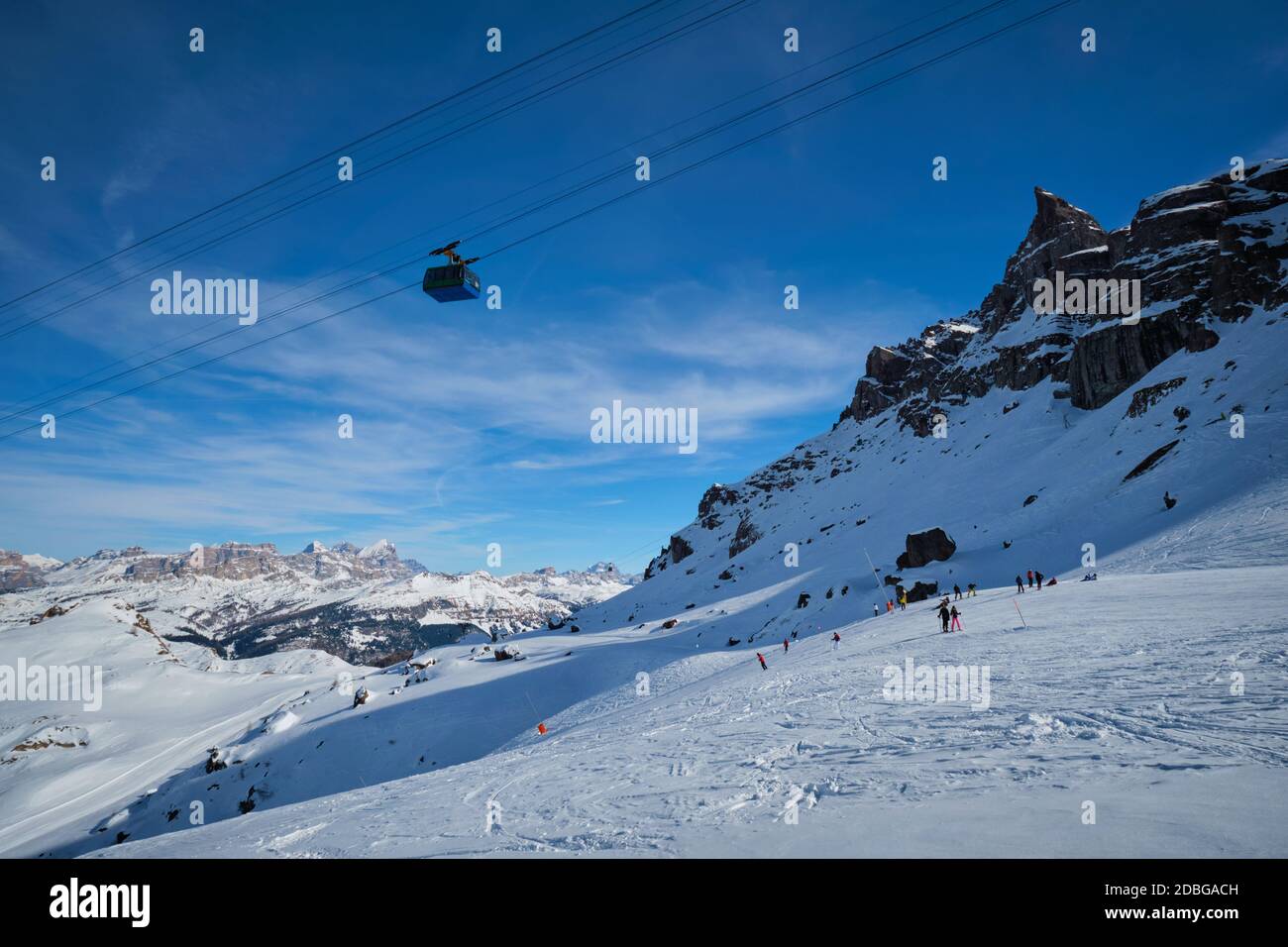 View of a ski resort piste with people skiing in Dolomites in Italy ...