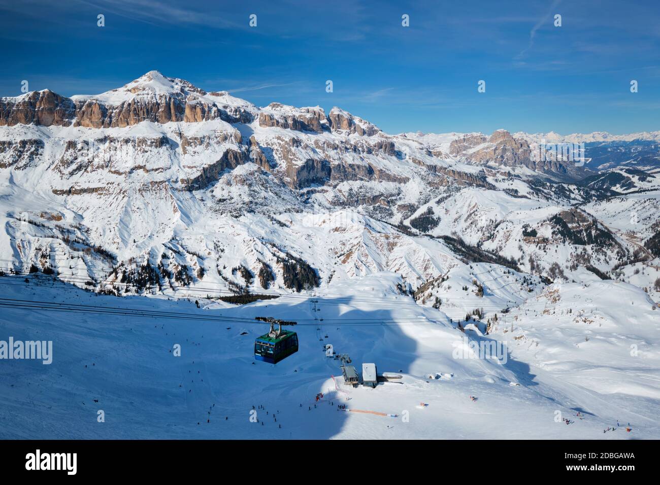 View of a ski resort piste with people skiing in Dolomites in Italy ...