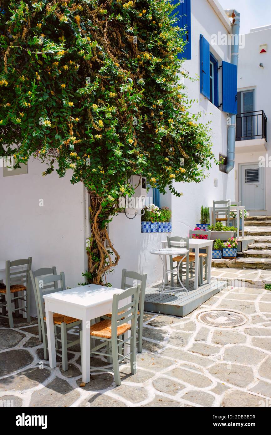 Picturesque narrow street with traditional whitewashed houses with cafe ...