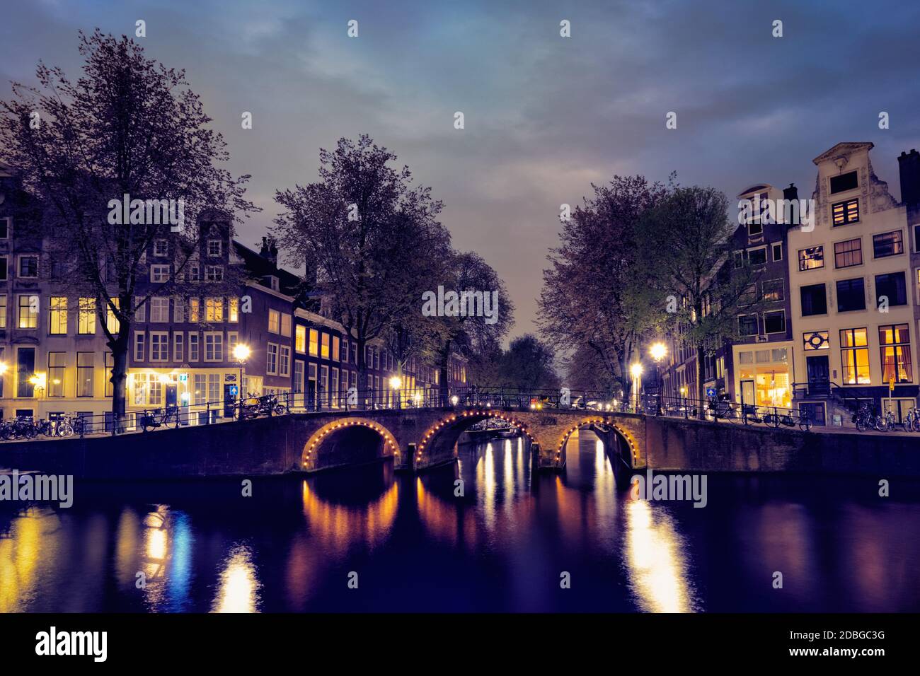 Night view of Amterdam cityscape with canal, bridge and medieval houses ...