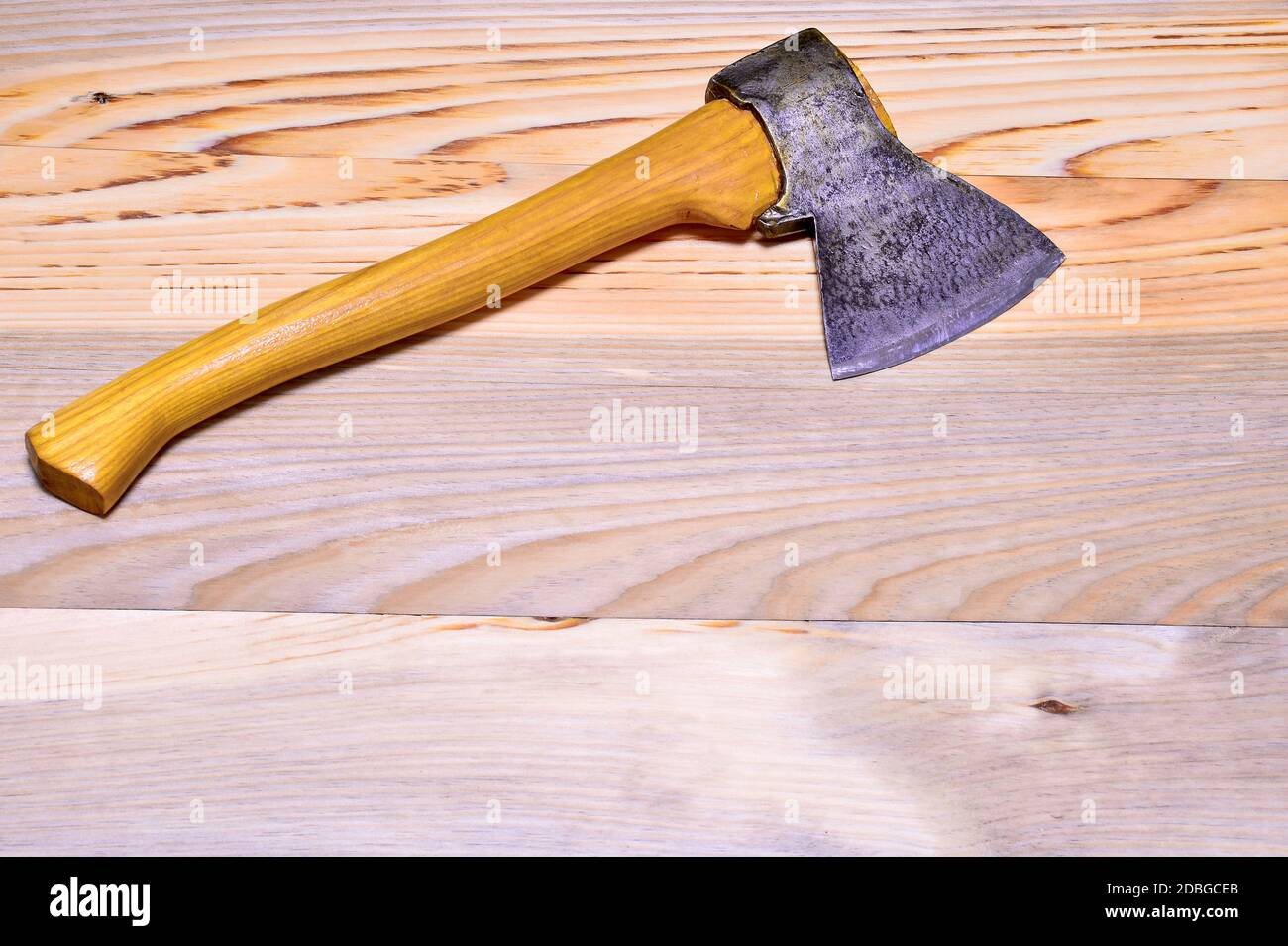 Old large carpenter's axe on a smooth wooden surface top view ...