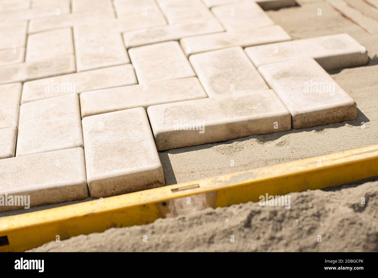 The master lays paving stones in layers. Garden brick pathway paving by ...