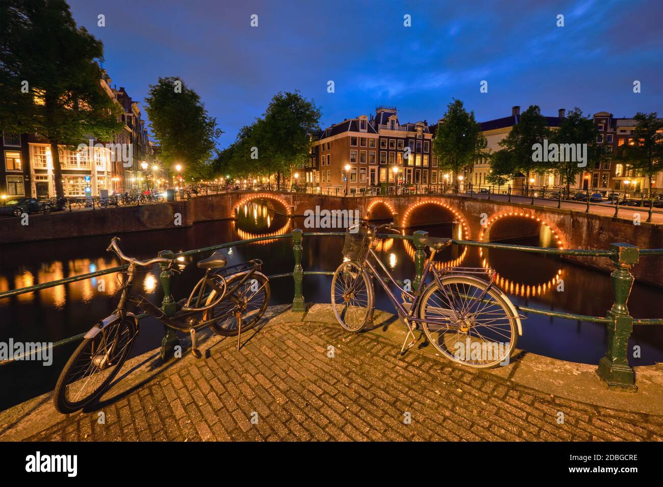 Night view of Amterdam cityscape with canal, bridge with bicycles and ...