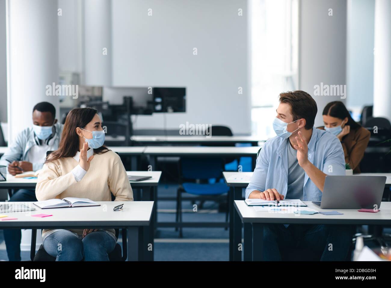 Diverse students wearing face masks greeting and waving Stock Photo - Alamy