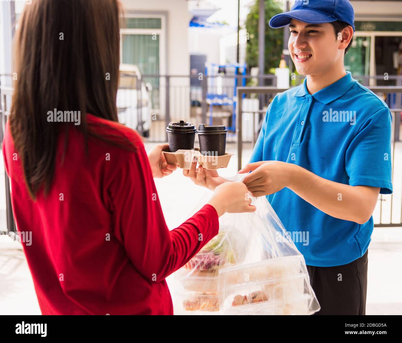 Asian young delivery man in blue uniform he making grocery service ...